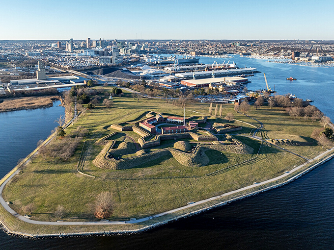 Fort McHenry stands as a green sentinel surrounded by water, the birthplace of our national anthem and proof that sometimes the most inspiring views come after the most terrifying nights.