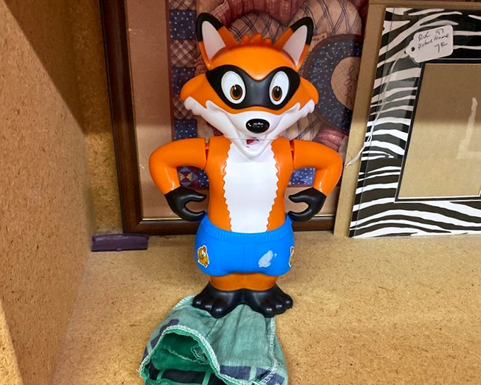 Meet the unofficial mascot of unexpected finds &ndash; a vintage fox figurine standing proudly among picture frames, ready to guard your bookshelf with cartoon charm.