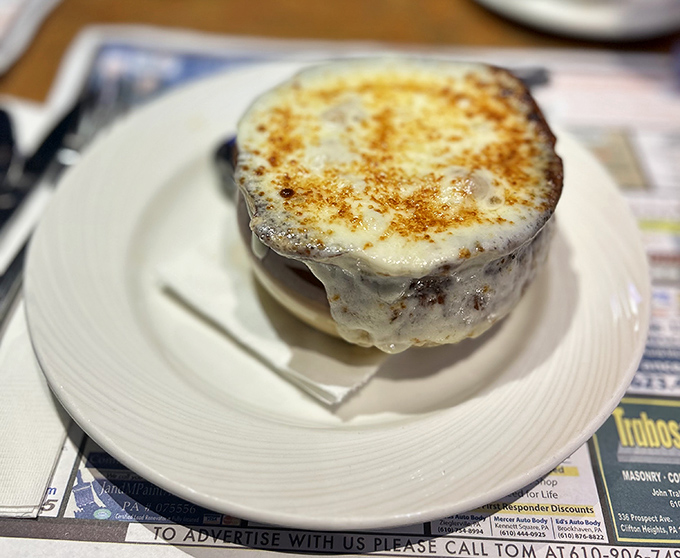 This isn't just French onion soup; it's a cheese-crowned masterpiece with a broth so rich it could buy real estate in Philadelphia's Main Line.