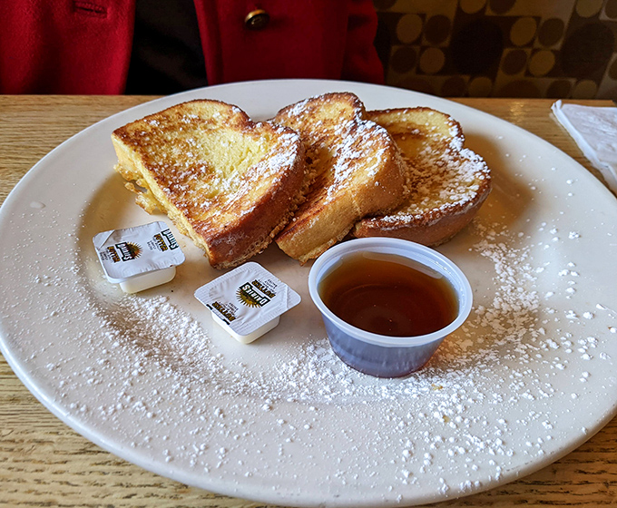 French toast that's dressed for success with a dusting of powdered sugar. Maple syrup on standby for the finishing touch.