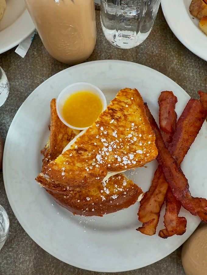 French toast that's achieved that mythical balance—crispy exterior, custardy interior—paired with real maple syrup that makes the plastic squeeze bottle stuff weep with inadequacy.