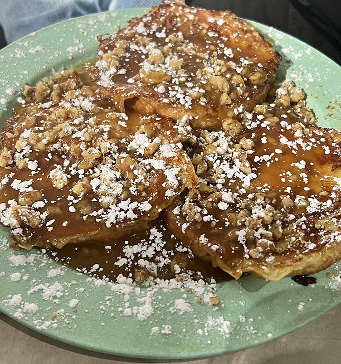 French toast thick enough to require structural engineering, golden-grilled and ready for its maple syrup baptism.
