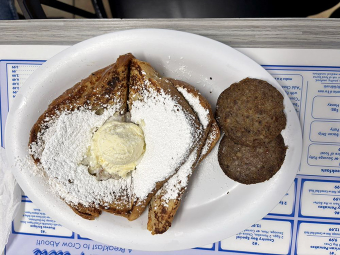 French toast that's dressed for success with a snow-white dusting of powdered sugar. The sausage patties stand guard, ensuring a perfect sweet-savory balance.