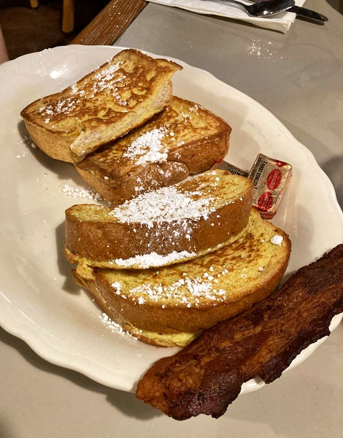 Four thick slices of French toast dusted with powdered sugar prove that sometimes simple done right beats fancy done wrong every single time.