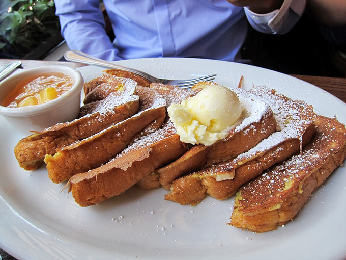 French toast that makes you question all other French toast &ndash; golden, crispy edges giving way to custardy centers under a snowfall of powdered sugar.