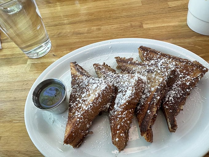 French toast transformed into dessert for breakfast. The powdered sugar snowfall makes it impossible not to smile before your first sip of coffee.