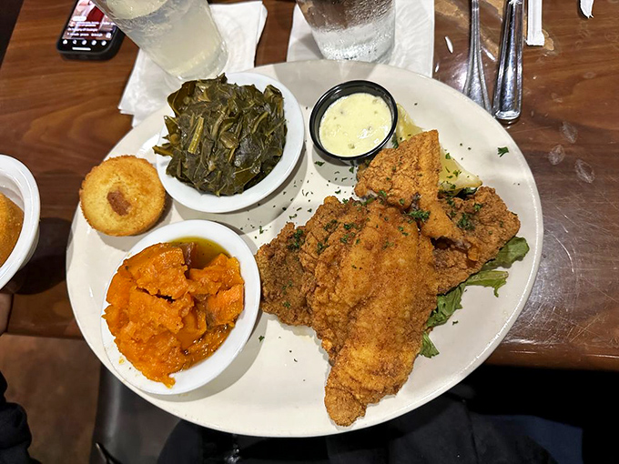 Fried catfish done right &ndash; golden armor protecting flaky treasure, with sides that deserve their own spotlight moment.