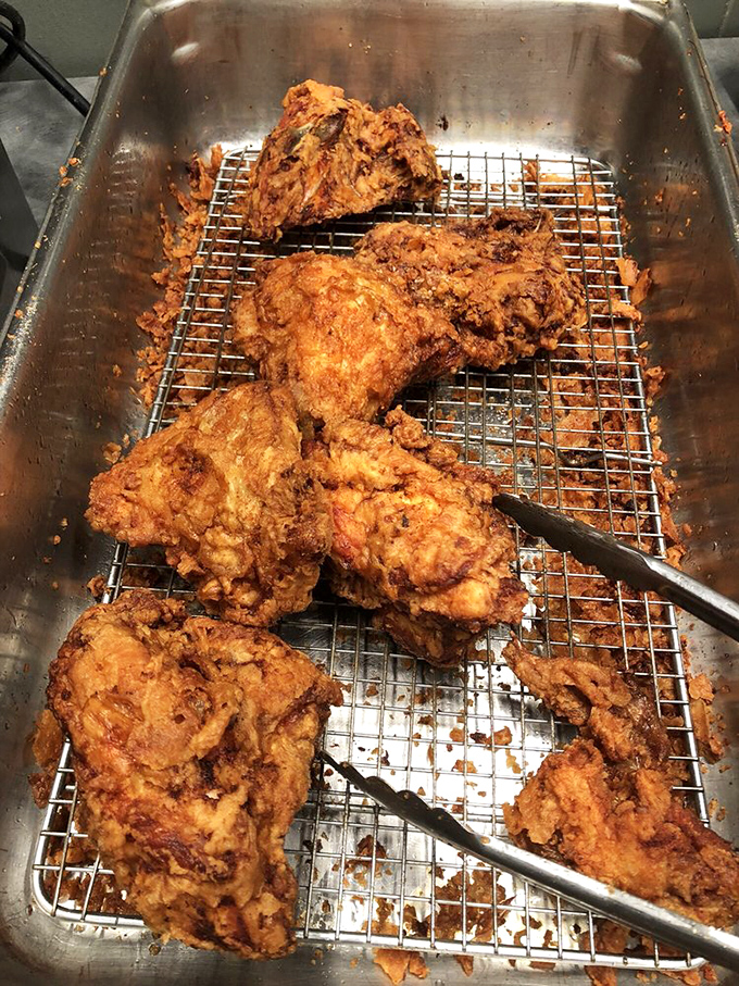 Fresh from the fryer, these chicken pieces rest on a cooling rack, their crispy exteriors practically whispering promises of flavor to come.