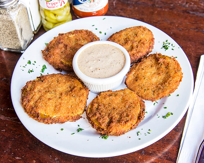 Golden-fried green tomatoes with a crispy coating that shatters just right, served with a dipping sauce worth bottling and taking home.