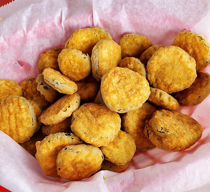 These fried pickles aren't just appetizers—they're little golden discs of vinegary perfection that disappear faster than Florida sunshine after a summer storm.