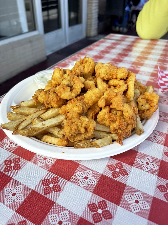 Golden-fried clam strips perched atop crispy fries—the kind of plate that makes you want to roll up your sleeves and forget you ever heard the word "calorie."