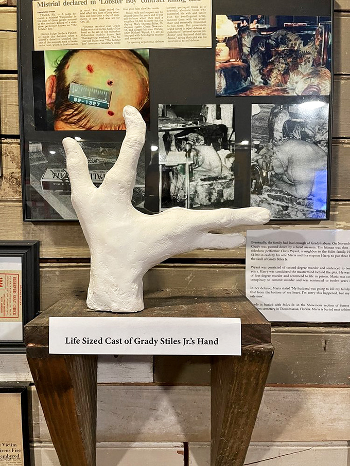 A life-sized cast of Grady Stiles Jr.'s hand sits beneath crime scene photos. The infamous "Lobster Boy" case represents the museum's unflinching approach to true crime history.