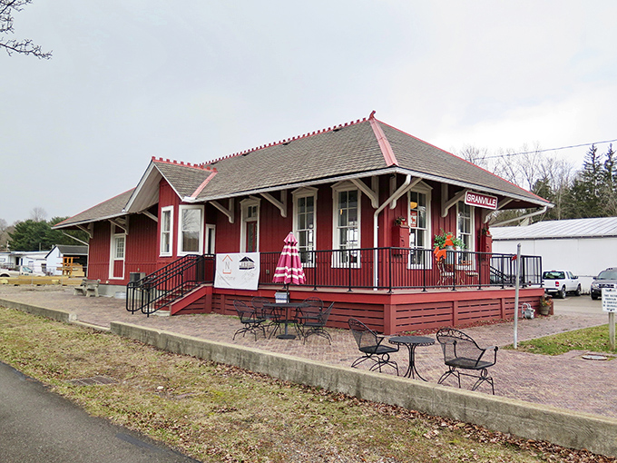 The crimson train depot stands as a Victorian time capsule, its wraparound porch practically begging you to sip lemonade while waiting for a train that's never late.