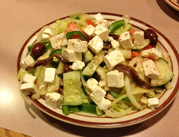 The Greek salad arrives like a Mediterranean vacation on a plate, with feta chunks so generous they're practically showing off.