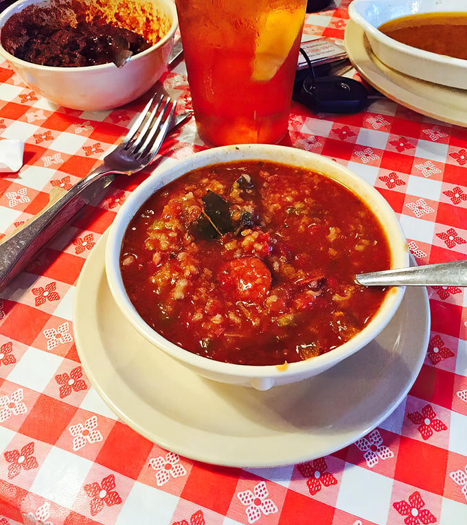 A bowl of gumbo that could make New Orleans jealous, sitting pretty on that classic red-checkered tablecloth like it owns the place.