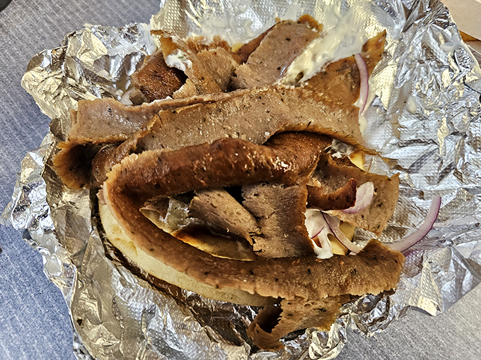 Layers of savory gyro meat peek out from their bread cocoon, a Mediterranean vacation that fits perfectly in your hand.