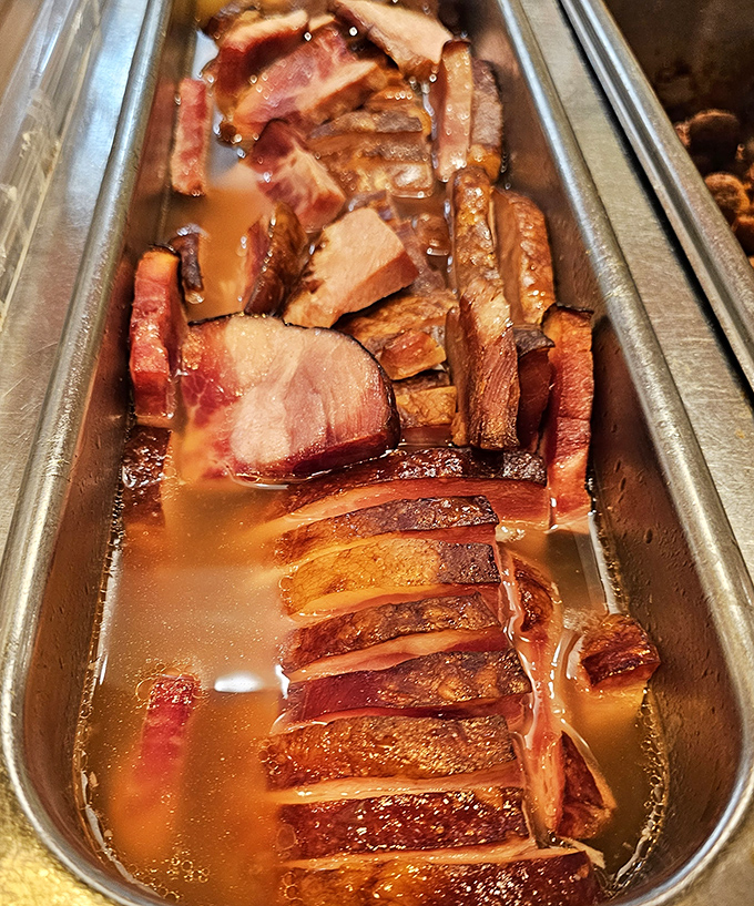 Glistening ham in its natural habitat&mdash;a steam tray where it's been lovingly bathing in its own juices, waiting for your plate.