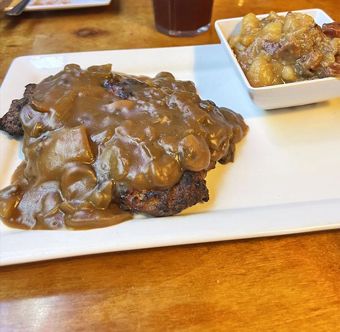 Hamburger steak swimming in mushroom gravy&mdash;comfort food that whispers, "Everything's going to be alright" with every savory bite.