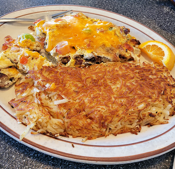 Crispy hash browns that crackle with each bite meet a cheese-blanketed omelet. This plate doesn't just serve breakfast&mdash;it celebrates it.