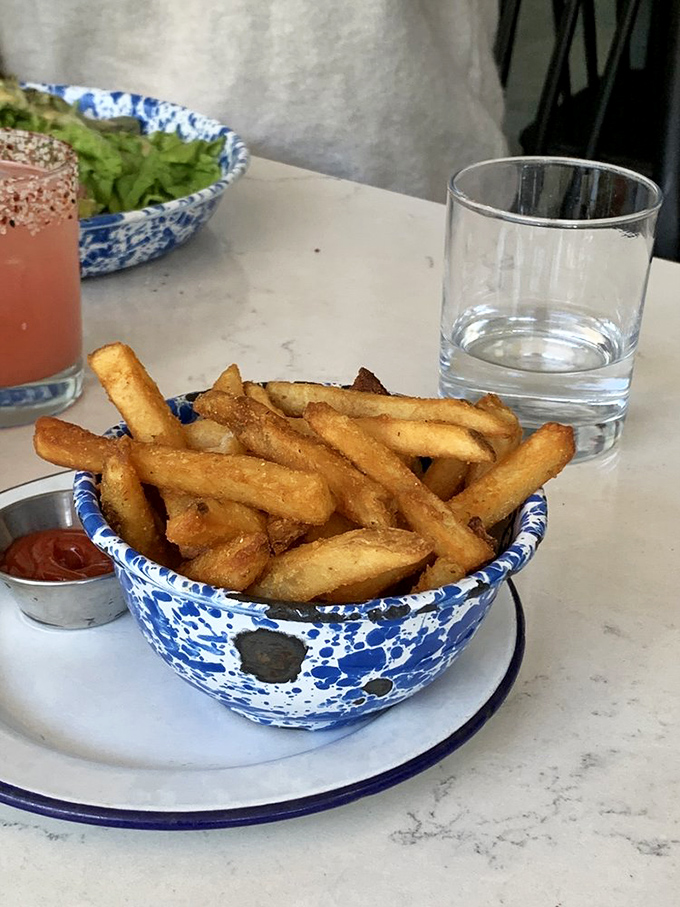 Golden, crispy home fries served in signature blue-speckled bowls&mdash;simple perfection that proves sometimes the supporting actors steal the show.