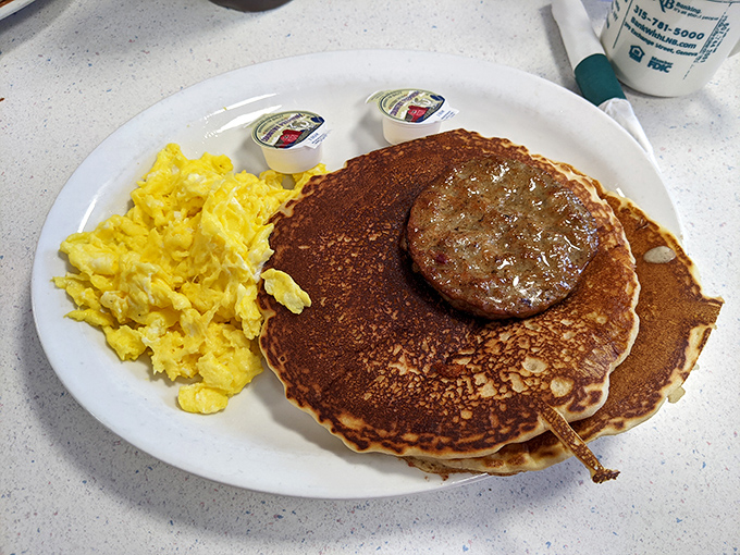 Breakfast perfection doesn't exi&mdash;wait, it does: golden pancakes with a sausage patty and eggs sunny enough to brighten your morning.