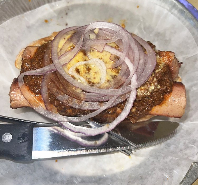 A hot dog elevated to art form, topped with savory chili and fresh onions&mdash;proof that simple pleasures done right can be the most satisfying.