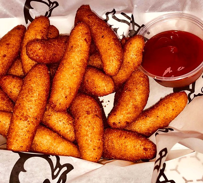Golden-brown hush puppies that crunch like nature's perfect counterpoint to tangy barbecue&mdash;crisp exterior, steamy cornmeal interior, and not a crumb left behind.