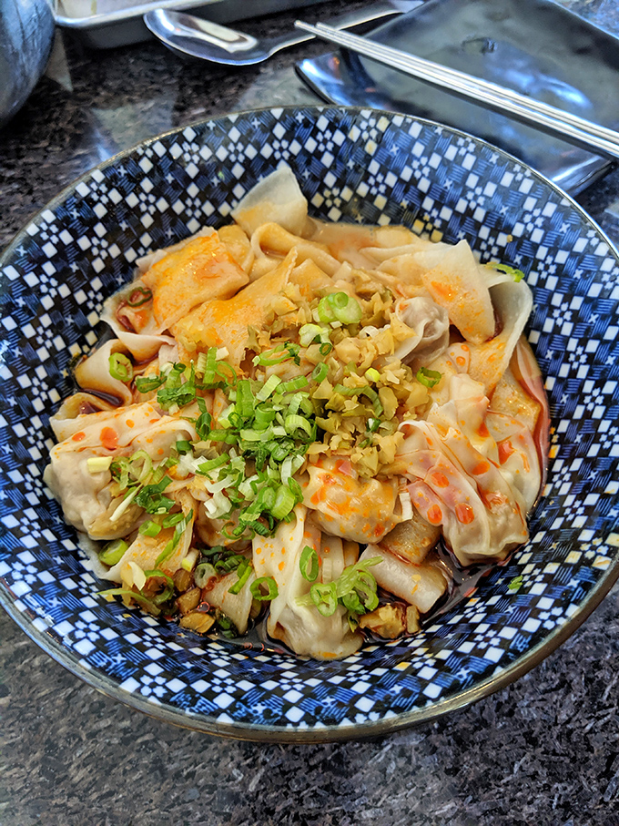 Plump wontons nestled in chili oil like little flavor bombs waiting to detonate. The scallions aren't garnish&mdash;they're essential supporting actors.