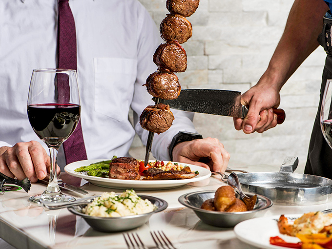 Meatballs on a skewer descend like savory planets in a carnivorous solar system. The knife stands ready for the delicious landing.