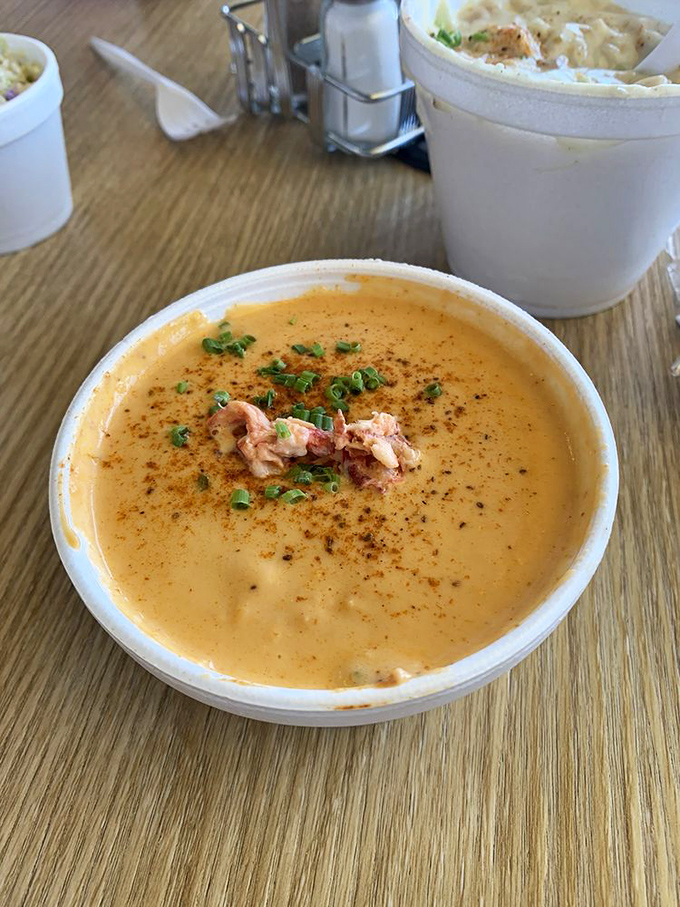The lobster bisque glows with an almost otherworldly orange hue, topped with a crown of fresh lobster meat. Liquid gold, by any reasonable definition.