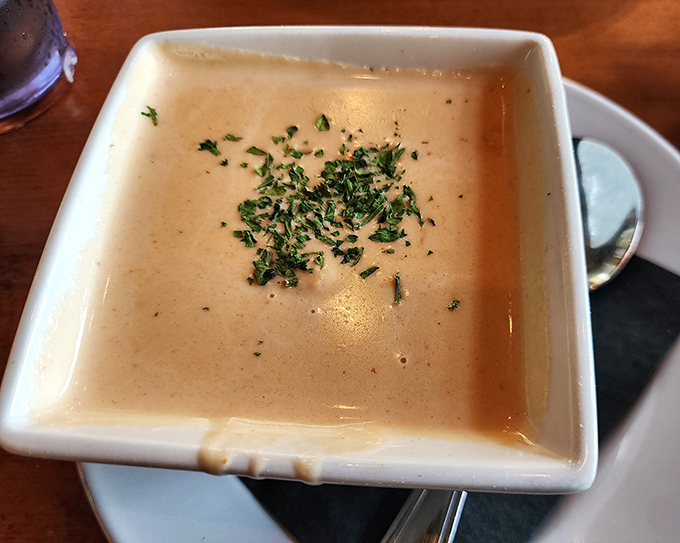 The lobster bisque arrives like a silky, coral-hued poem in a bowl, garnished with fresh herbs that whisper, "Yes, this is the real deal."