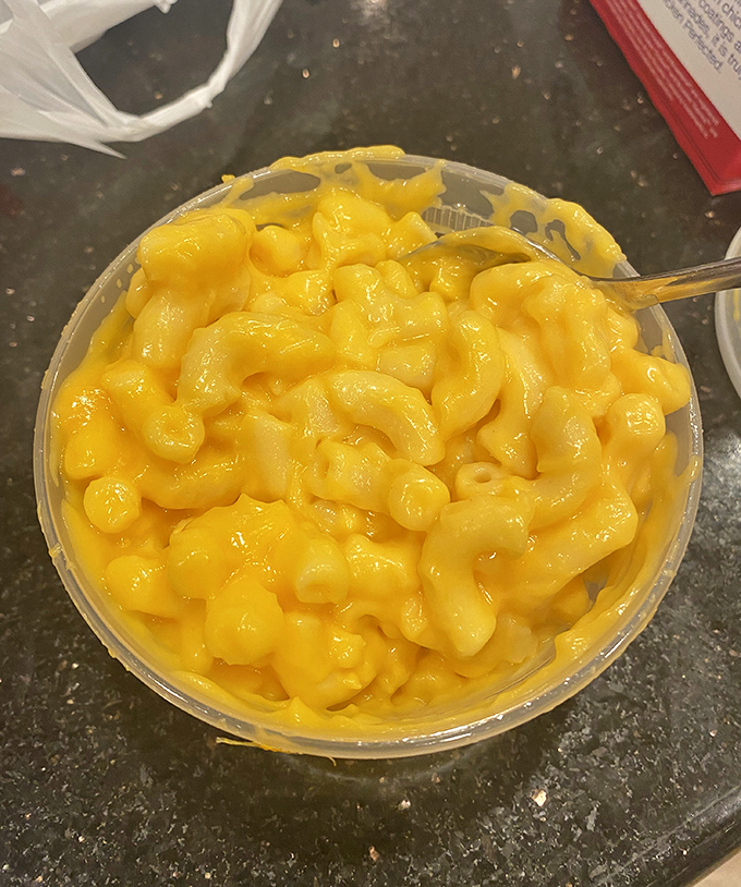 Mac and cheese so gloriously yellow it could guide ships to shore, with each spoonful delivering childhood memories upgraded for adult taste buds.