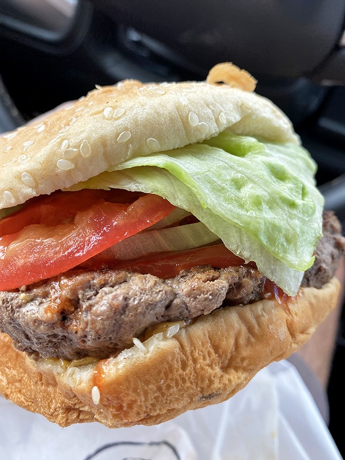 This isn't just a burger—it's a skyscraper of satisfaction with structural integrity that would impress Frank Lloyd Wright himself.