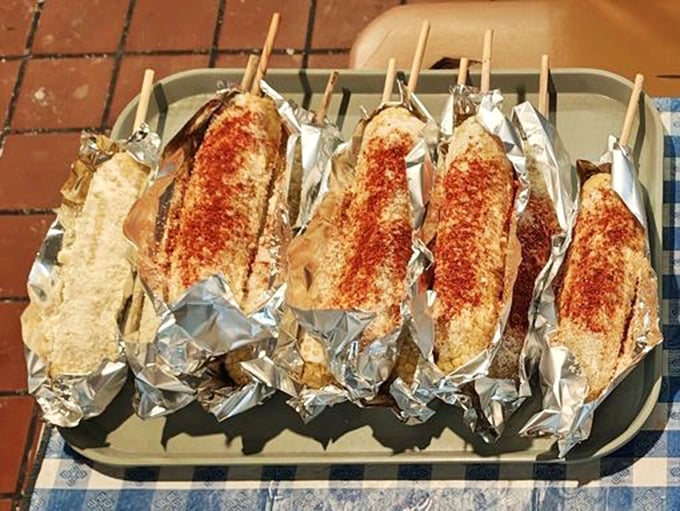 Elotes wrapped in foil like precious gifts, dusted with chile powder that hints at the sweet-spicy-savory symphony waiting inside. Corn elevated to art form.