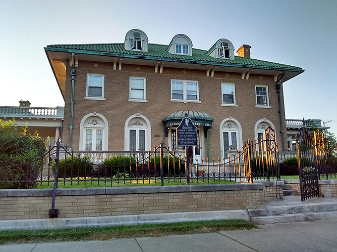 Mugivan Manor's elegant brick facade and wrought iron gate whisper stories of circus wealth from an era when entertainment didn't require a monthly subscription.