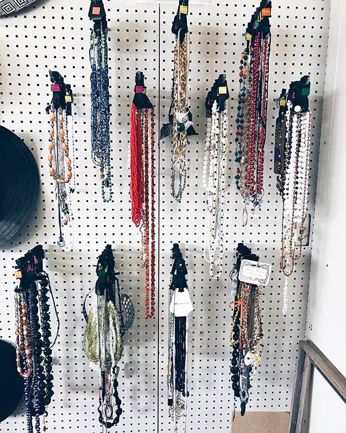 Jewelry that tells stories hanging in patient formation. Each necklace awaits its next chapter, like characters in a well-curated anthology.