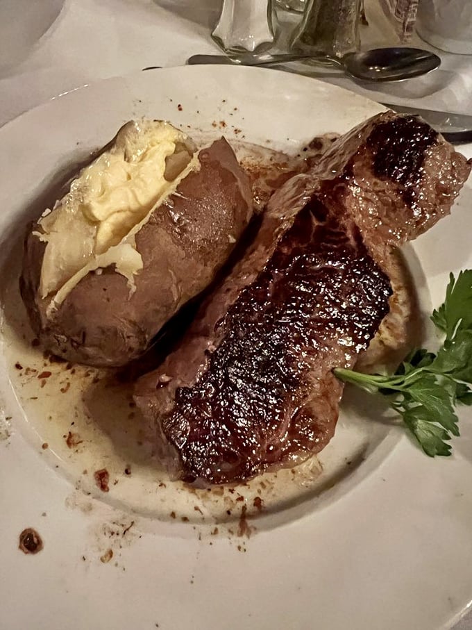 This New York Strip isn't just a steak&mdash;it's a life-affirming experience with a baked potato that's practically begging to be your side hustle.