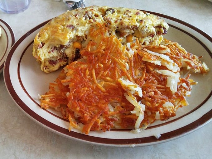 This isn't just an omelet – it's a masterclass in breakfast architecture, with those hash browns providing the perfect crispy counterpoint to fluffy eggs.