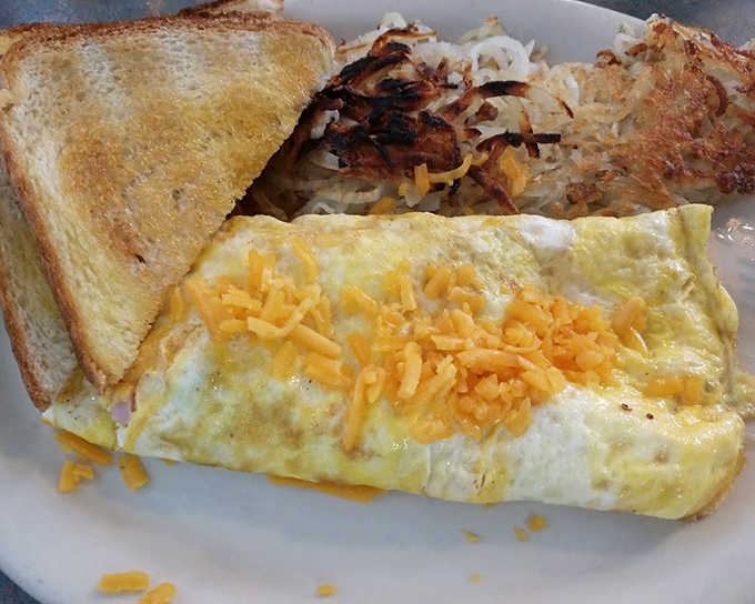 Breakfast perfection: a ham and cheese omelet that's fluffy on the inside, slightly crisp at the edges, with hash browns to die for.