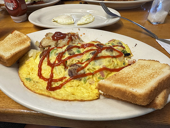 This isn't just any omelet&mdash;it's a fluffy yellow canvas painted with savory fillings and a bold ketchup signature that screams "vacation mode activated!"