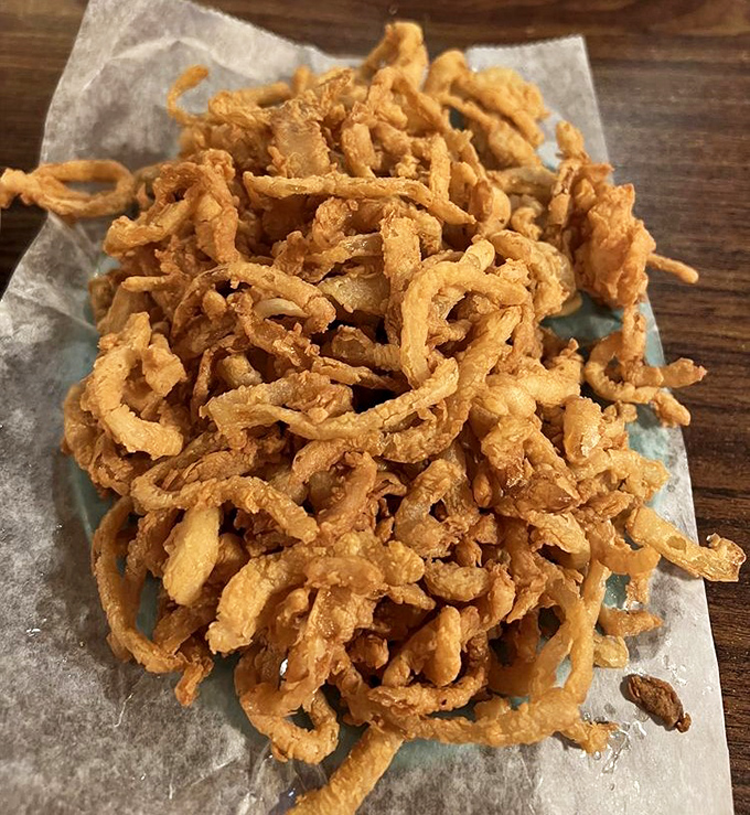 These onion strings aren't just a side dish; they're a crispy, golden tangle of happiness that demands to be shared&mdash;or hoarded.