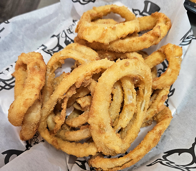 Onion rings that shatter with geological precision &ndash; crispy armor protecting sweet, tender onion within. The perfect supporting actor to any barbecue star.