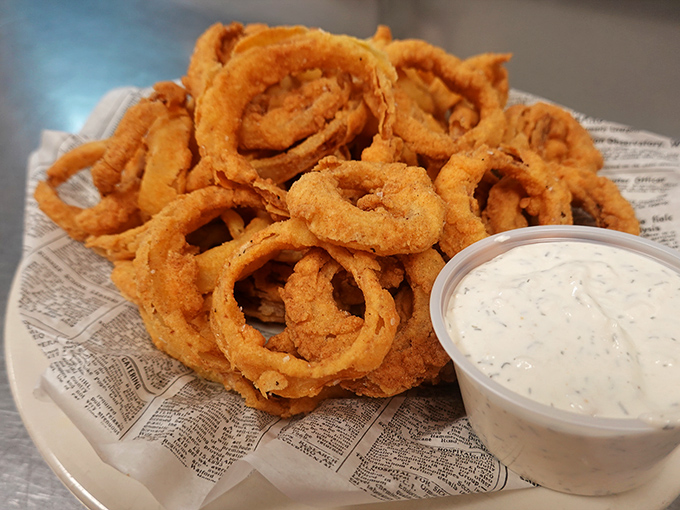 Onion rings stacked higher than your weekend expectations. That golden-brown batter shatters with each bite, revealing sweet onion treasure within.