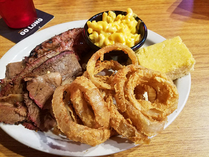 Brisket with a smoke ring so perfect it could make a Texan weep, paired with onion rings that crunch loud enough to drown out the nearby racecars.