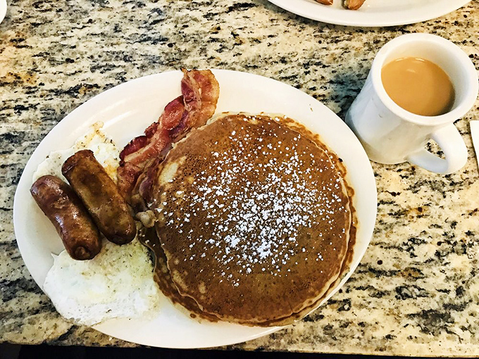 This isn't just a pancake&mdash;it's a fluffy canvas of possibility, dusted with powdered sugar and flanked by bacon that's achieved crispy-chewy perfection.
