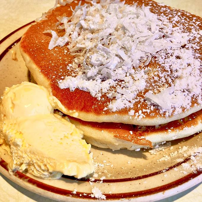 Coconut-dusted pancakes that make you question why mainland pancakes even bother. The butter melts like your resolve to eat sensibly.