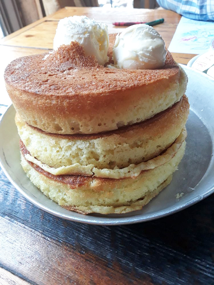 Pancakes stacked higher than your weekend ambitions. That melting butter on top is performing a slow, beautiful swan dive into breakfast perfection.