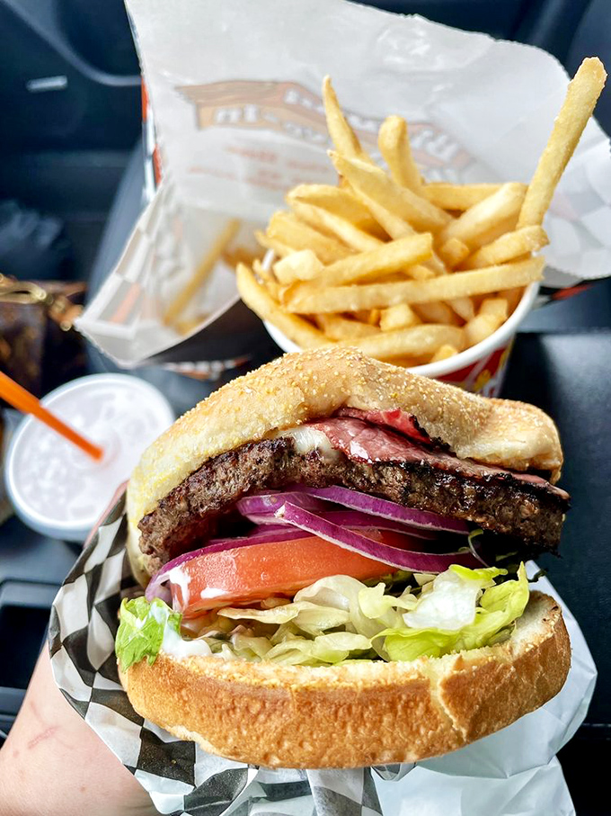Behold the burger in its natural habitat—the car dashboard. This is drive-in dining at its finest, where your vehicle becomes the best seat in the house..