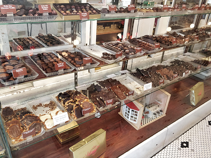 The chocolate display case&mdash;where adults press their noses against glass like children. Each handcrafted piece arranged with the precision of museum artifacts.