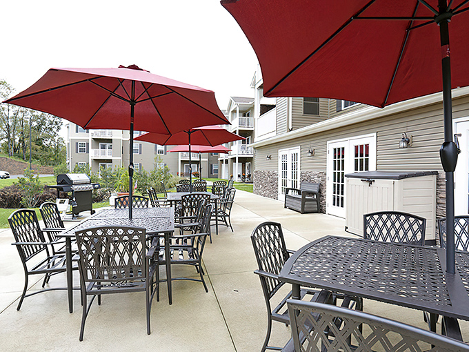 The outdoor patio area serves as summer's living room, where conversations flow as freely as the Pennsylvania breeze under those cherry-red umbrellas.